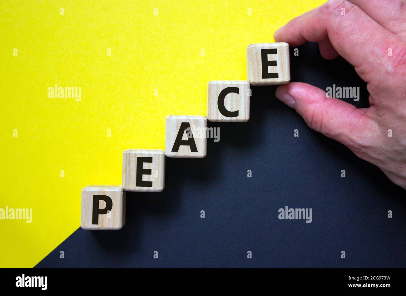 Wood blocks with word 'peace' stacking as step stair on paper yellow ...