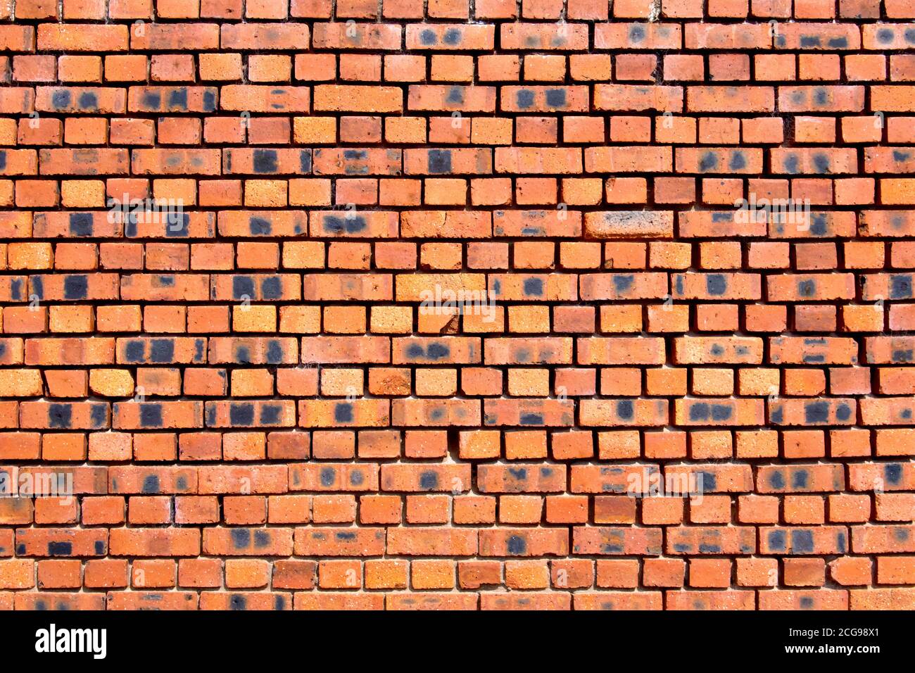 A shot of a red brick wall, showing the regular linear pattern created ...