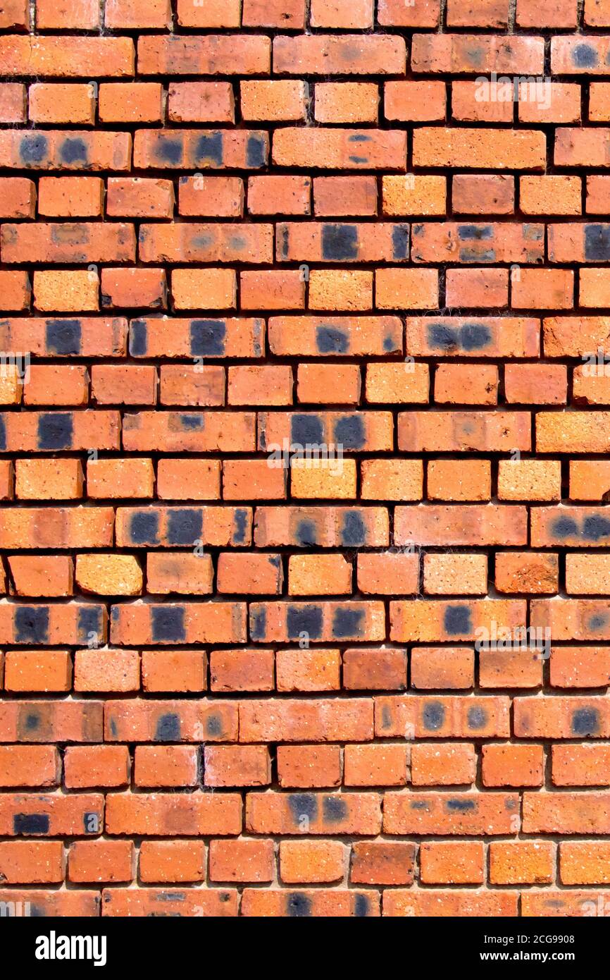 A shot of a red brick wall, showing the regular linear pattern created ...