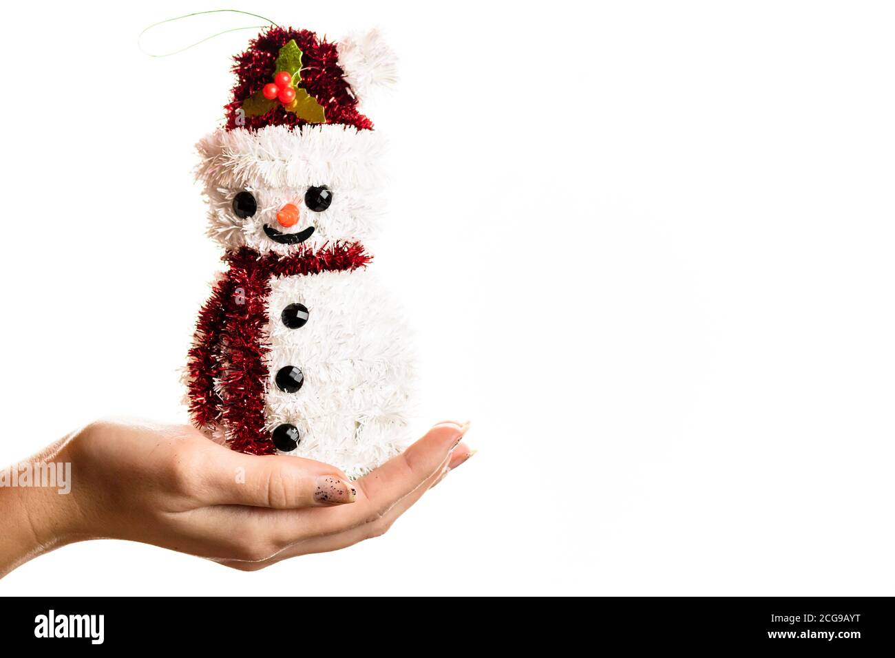Hand holding Christmas snowman figurine isolated on white background ...