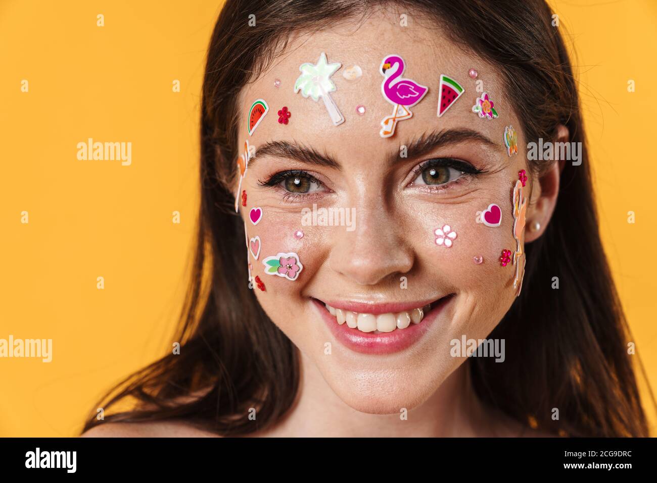 Image of young cheerful woman with stickers on face laughing at camera ...