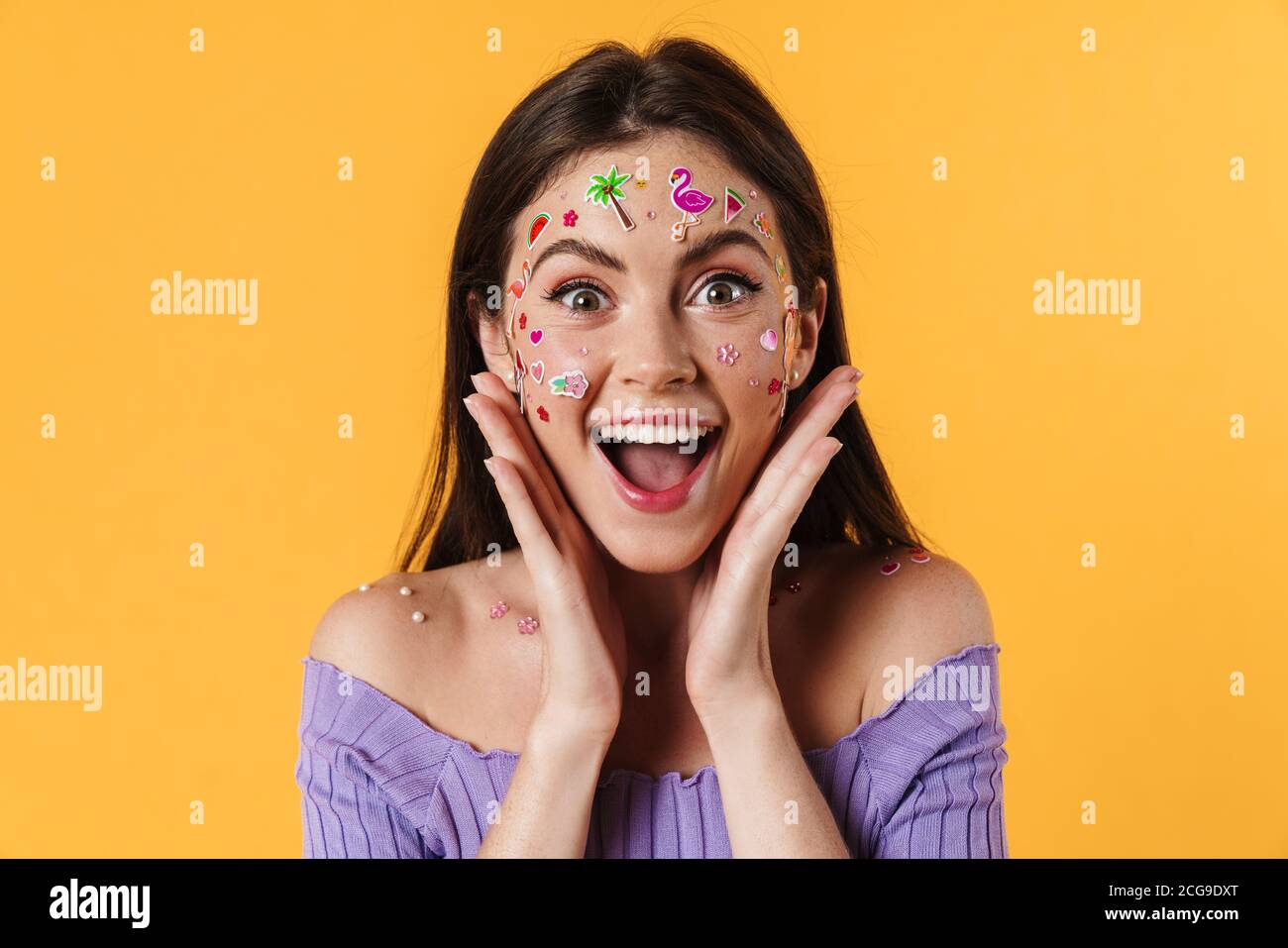 Image of delighted woman with stickers on face expressing surprise on ...