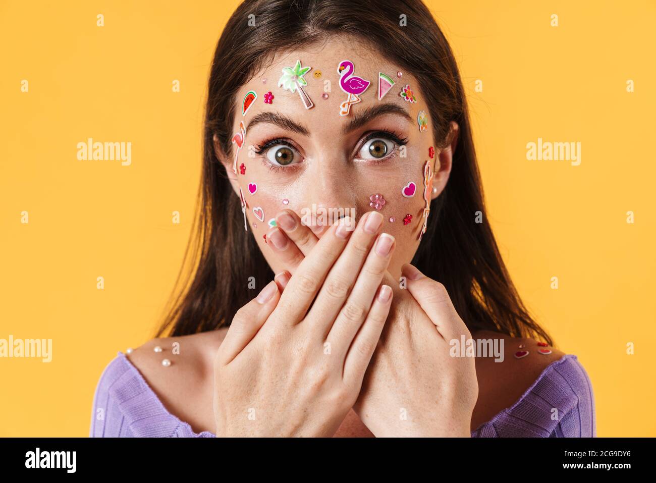 Image of shocked woman with stickers on face covering her mouth ...
