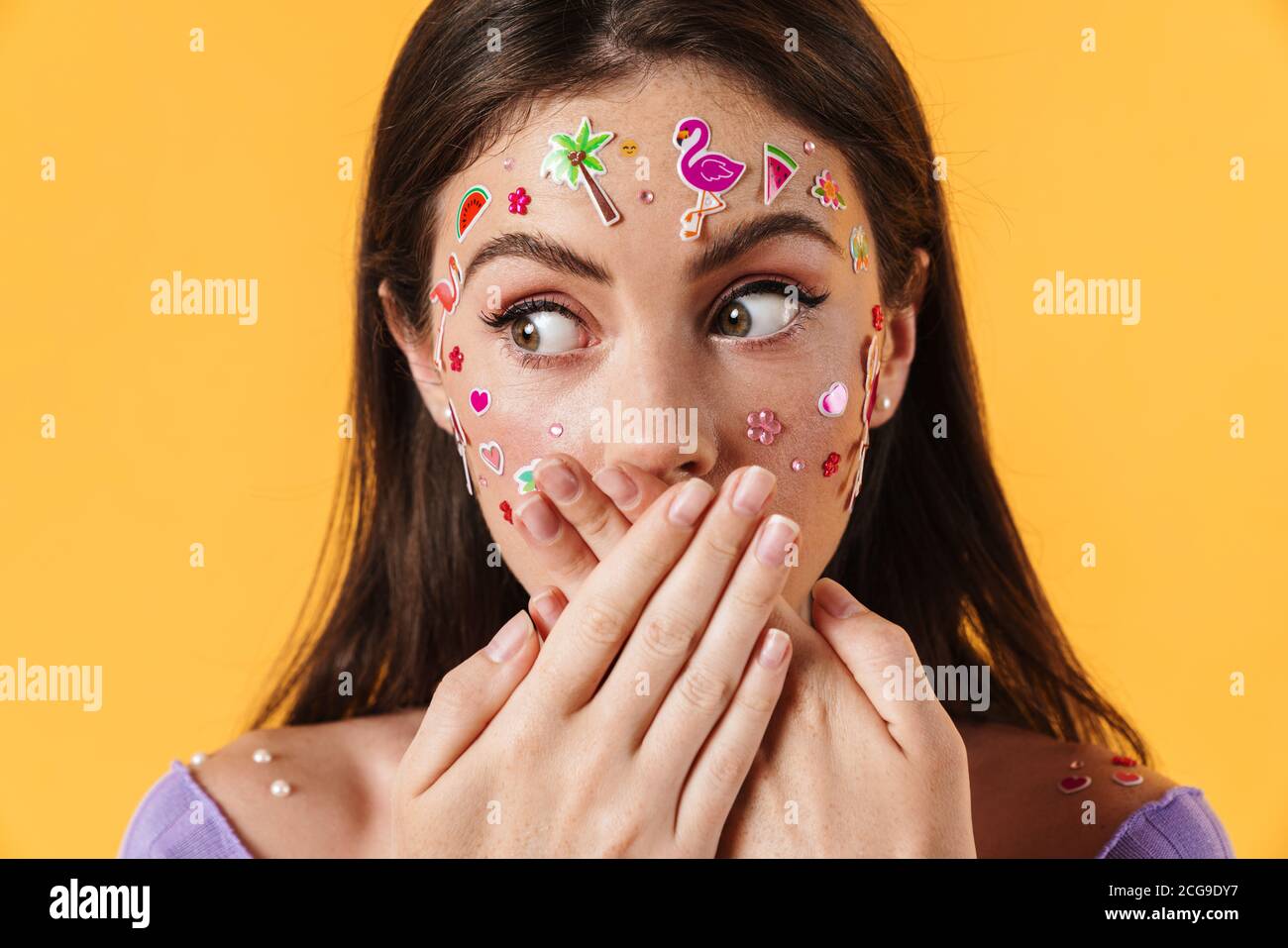 Image of shocked woman with stickers on face covering her mouth ...