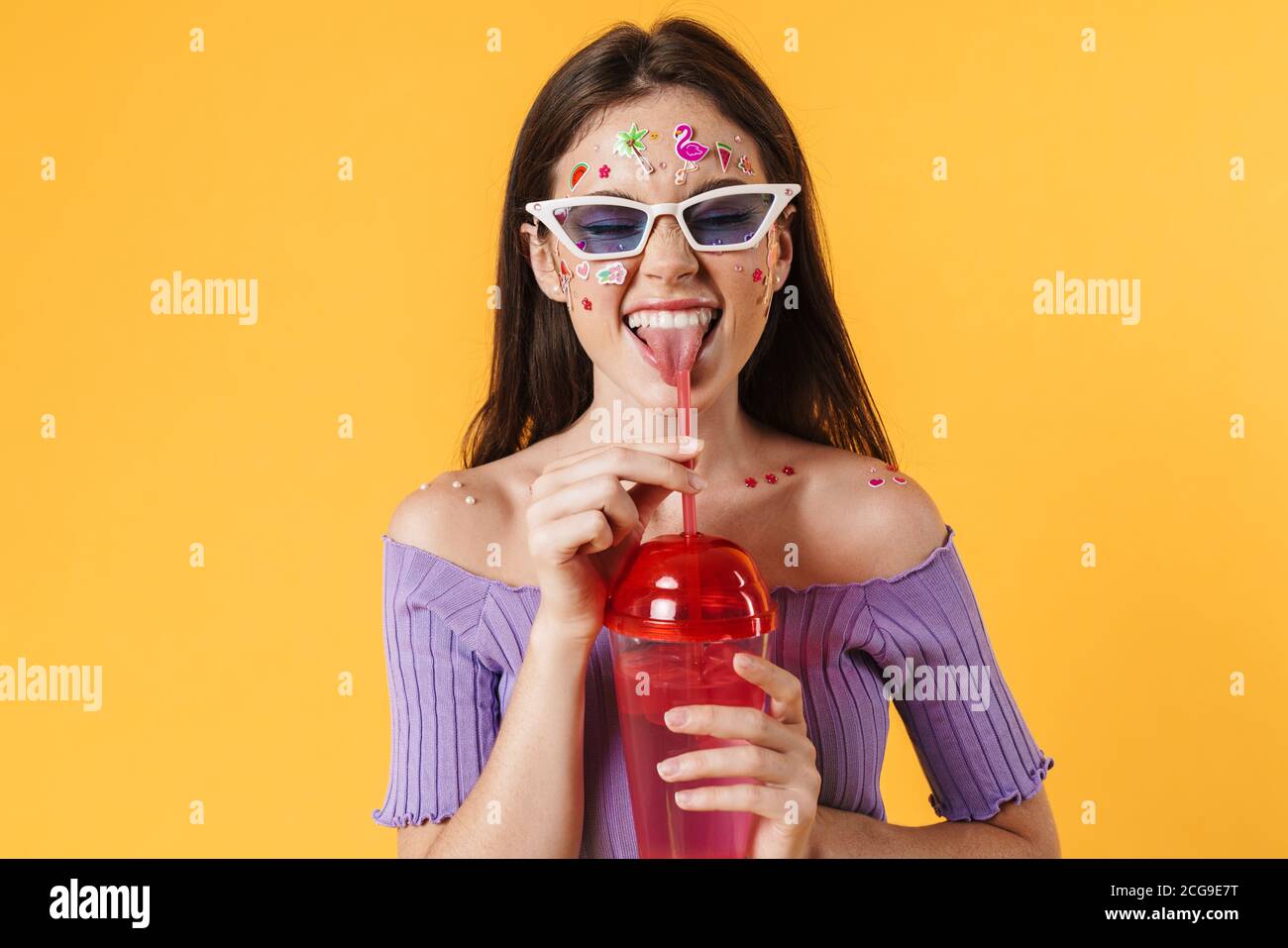Image of joyful woman with stickers on face drinking cocktail and ...