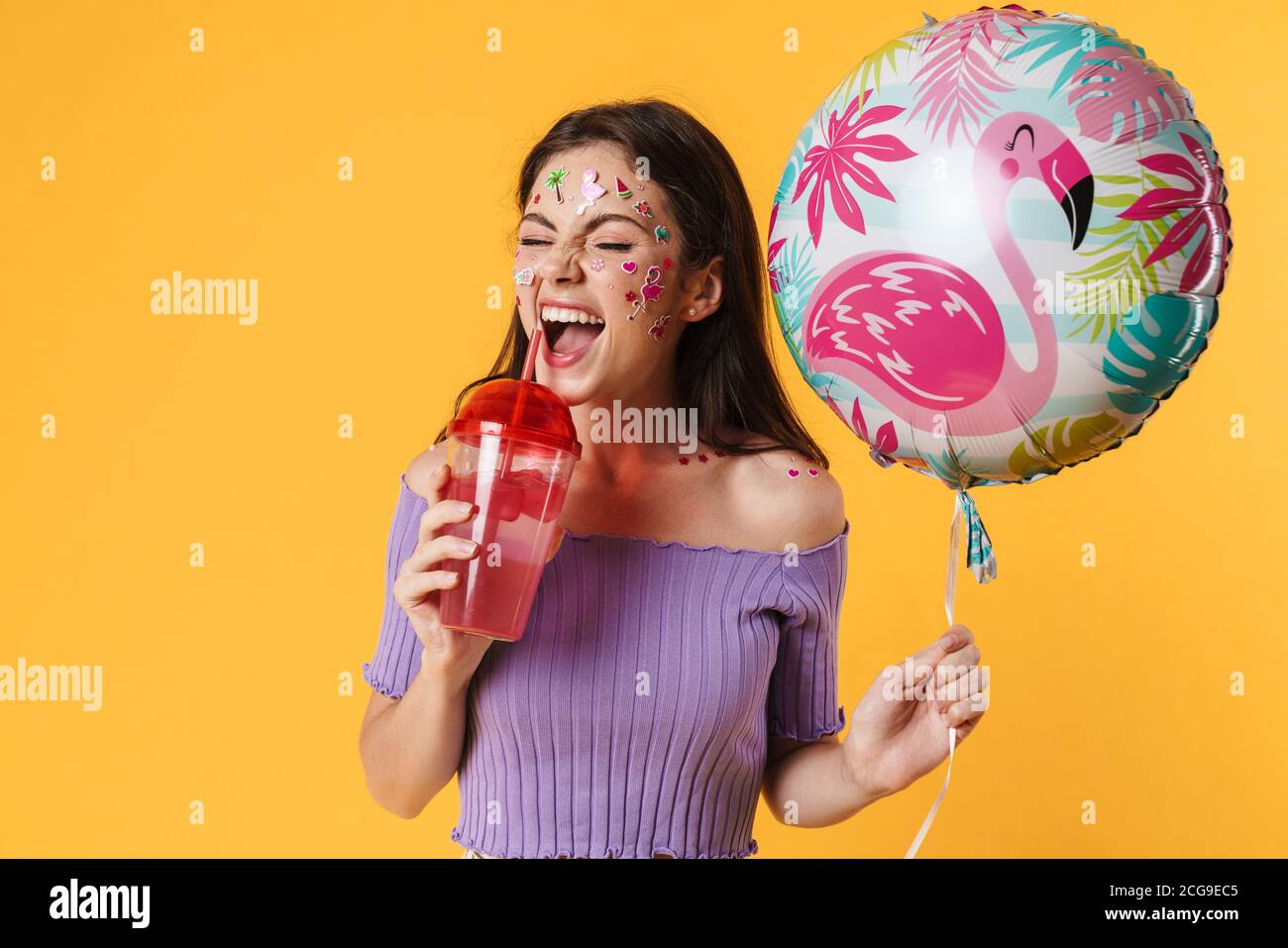 Image of laughing woman with stickers on face holding balloon and ...