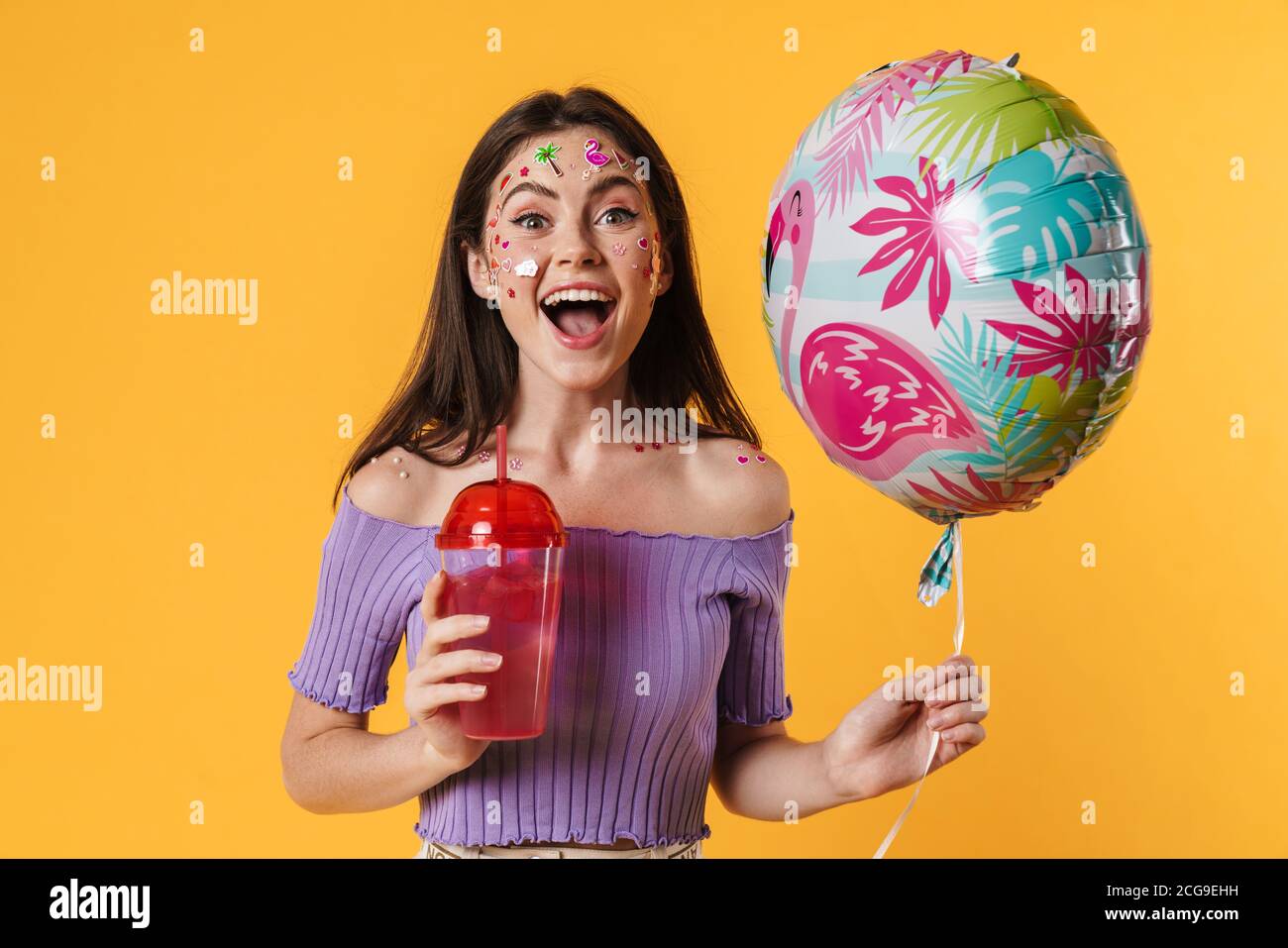 Image of laughing woman with stickers on face holding balloon and ...