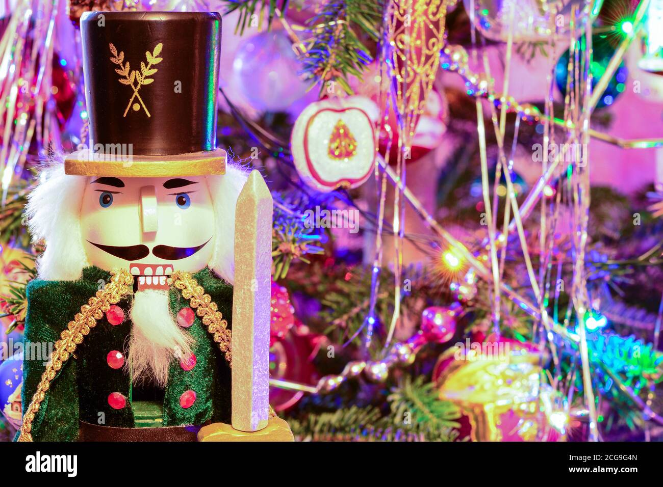 Nutcracker soldier under decorated colorful Christmas tree. Traditional ...