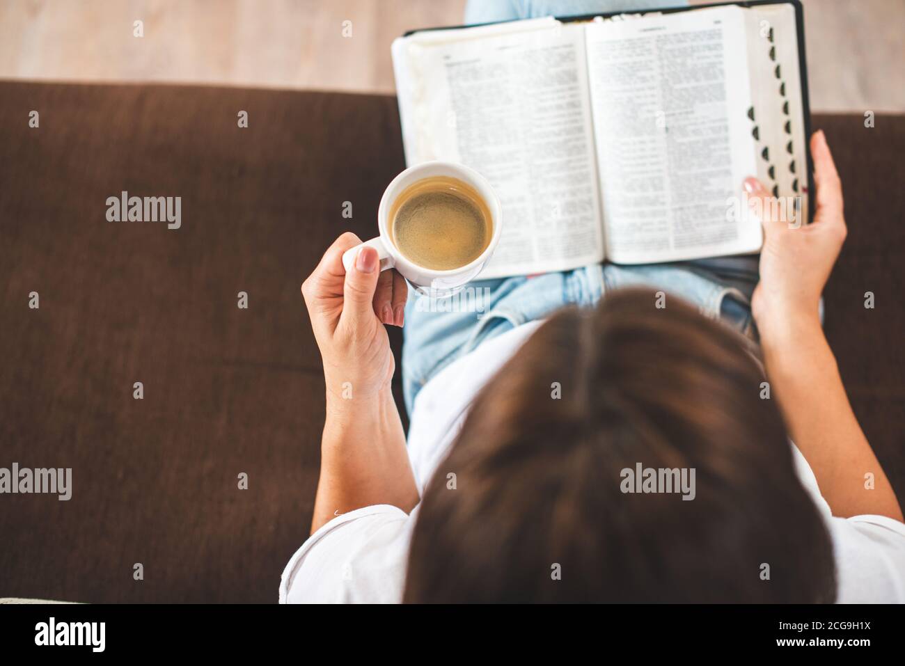 Woman hand holding cup of coffee and reading Holy bible Stock Photo - Alamy