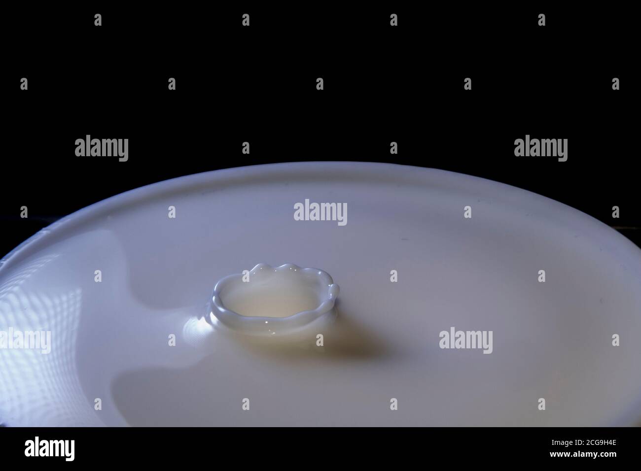 Milk drop falling on a cup full of milk Stock Photo - Alamy