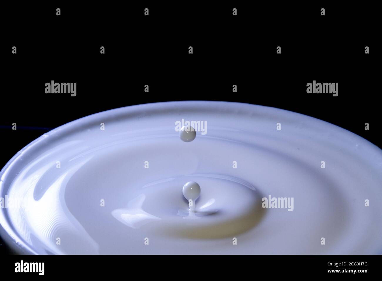 Milk drop falling on a cup full of milk Stock Photo - Alamy