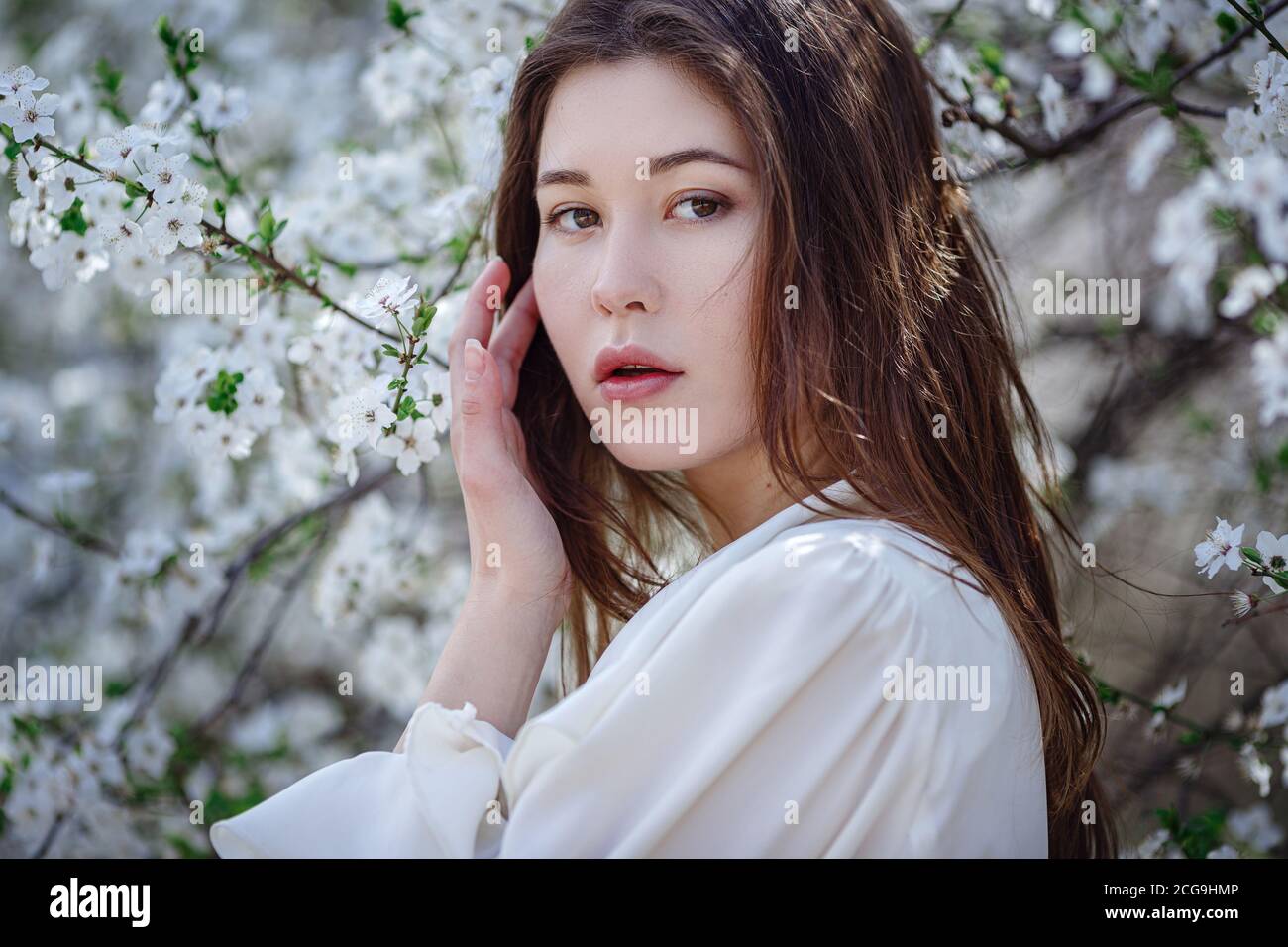 young asian woman in a flowering garden. romantic image of stylish ...