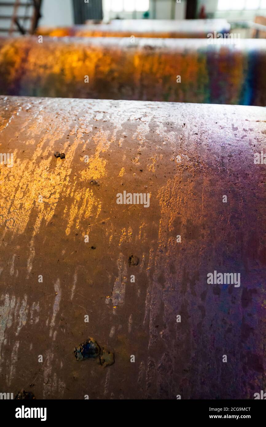 Titanium cylinder before mechanical metalwork on turning lathe. Color ...