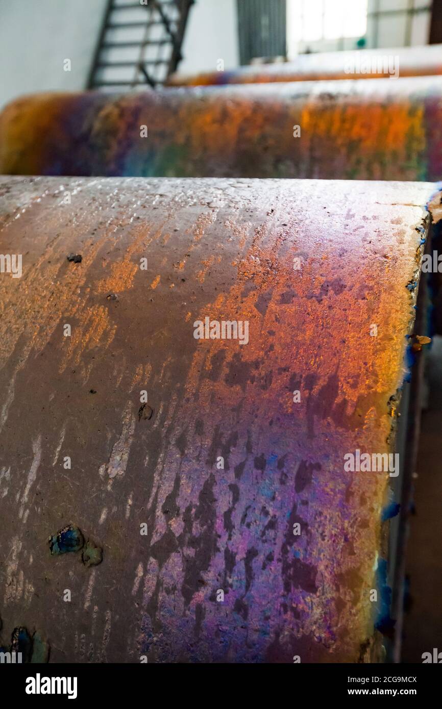 Titanium cylinder before mechanical metalwork on turning lathe. Color ...