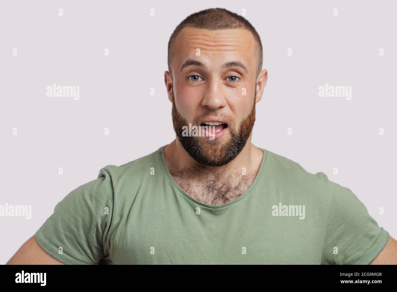 Cheerful young man winking over white background Stock Photo - Alamy