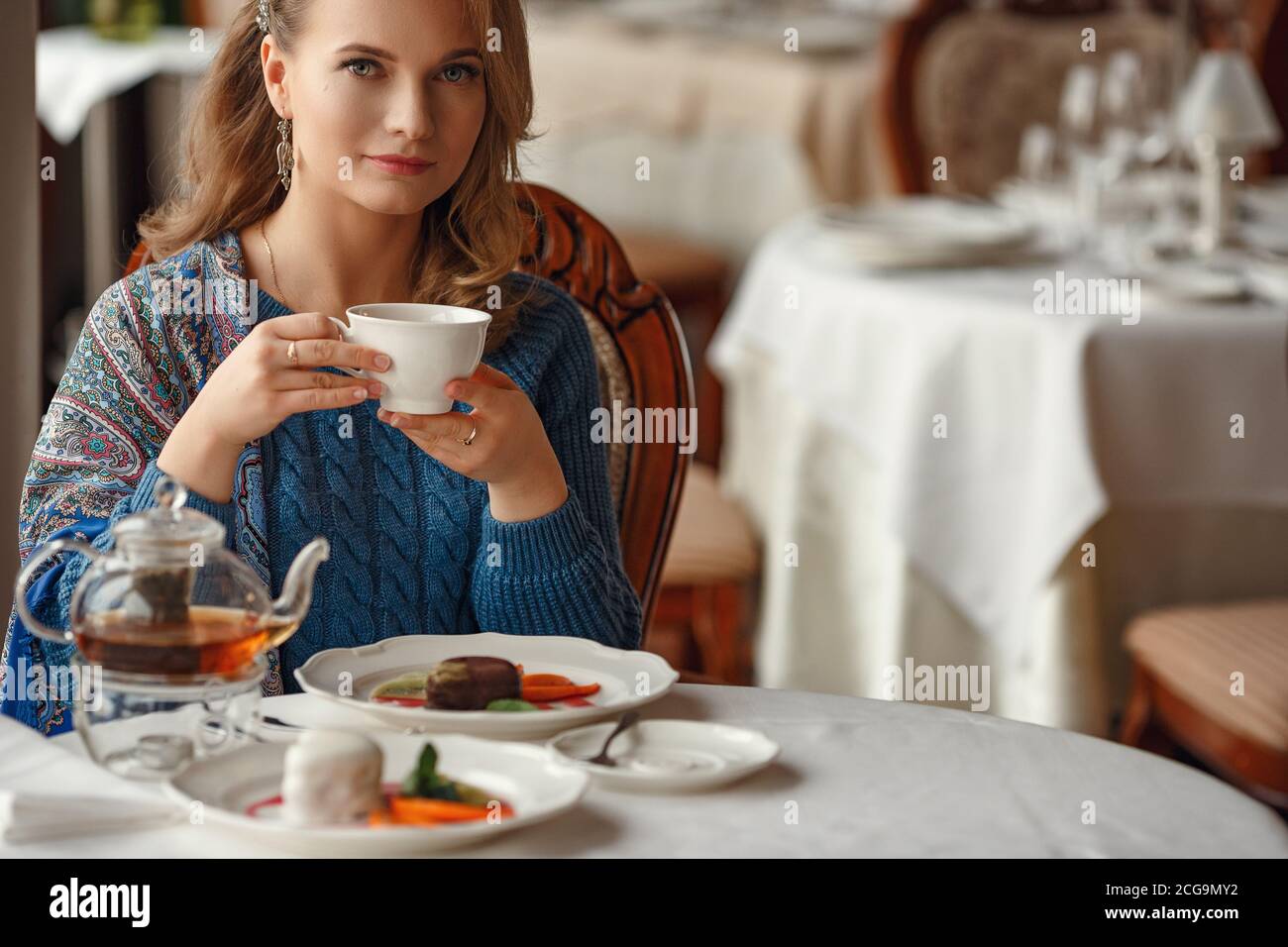 Beautiful smiling women drinking tea at cozy cafe. Businesswomen take a ...