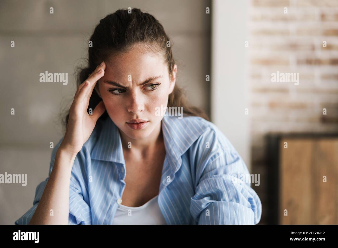 Image of a young negative girl with headache indoors at home using ...