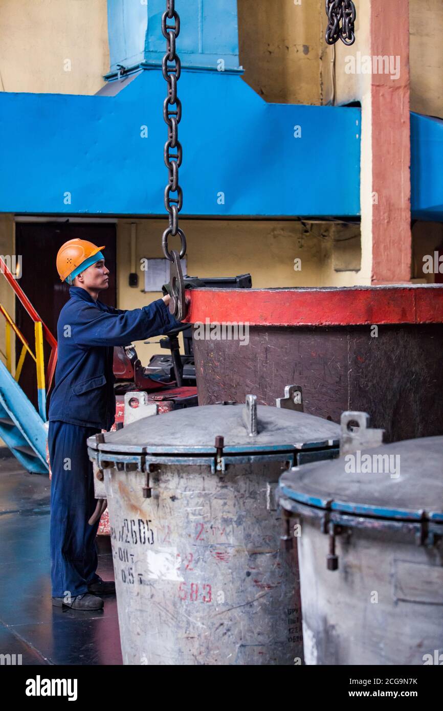 Titanium metallurgy plant. Asian metallurgist worker with storage ...