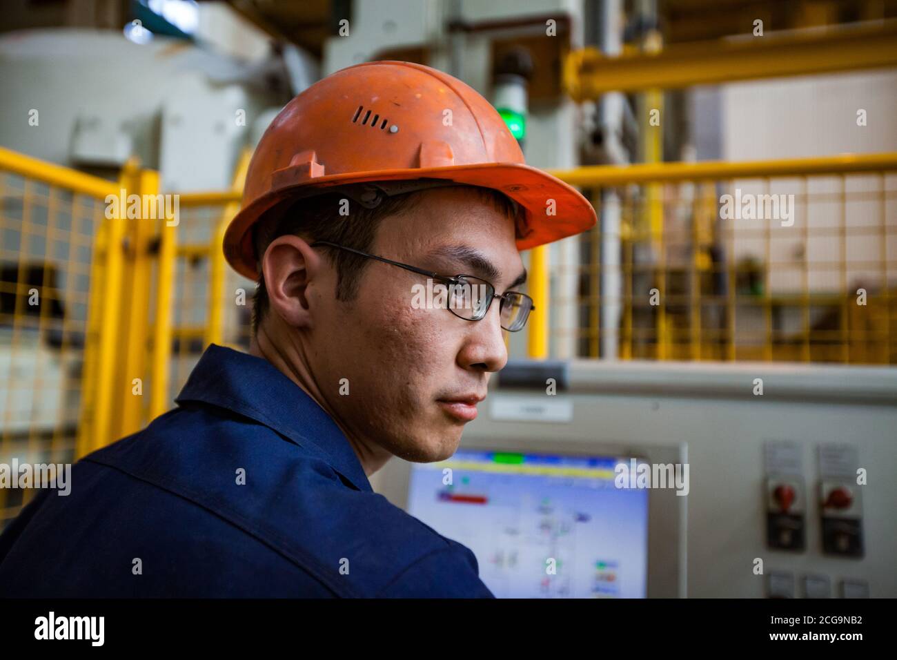 Young asian worker man on titanium metallurgy plant. Control operator ...