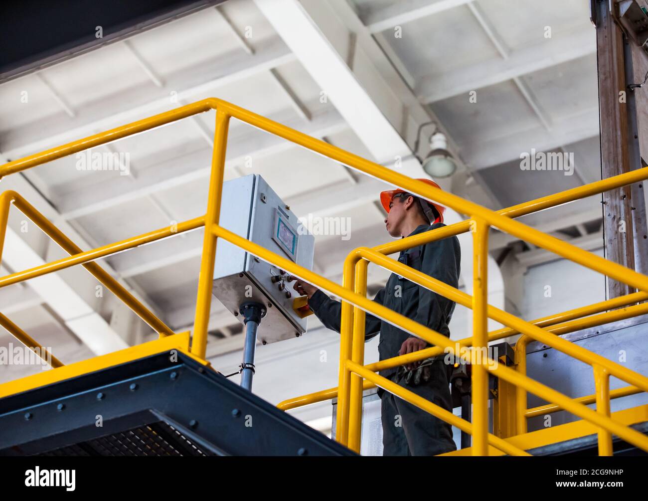 Worker controls the processing on pressing machine. Squeezing the ...