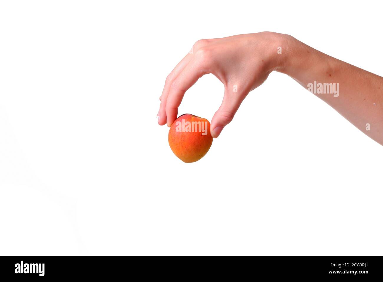 Female hand with tasty apricot on white background. Cream for hands and ...