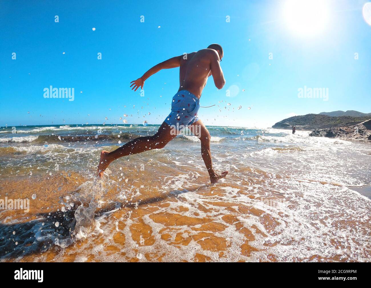 Slow motion of man sprinting at the beach. Shirtless sportsman sprint ...