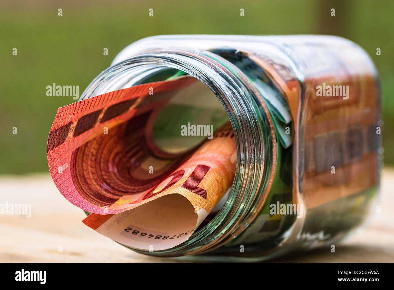 Composition with saving money banknotes in a glass jar. Concept of ...