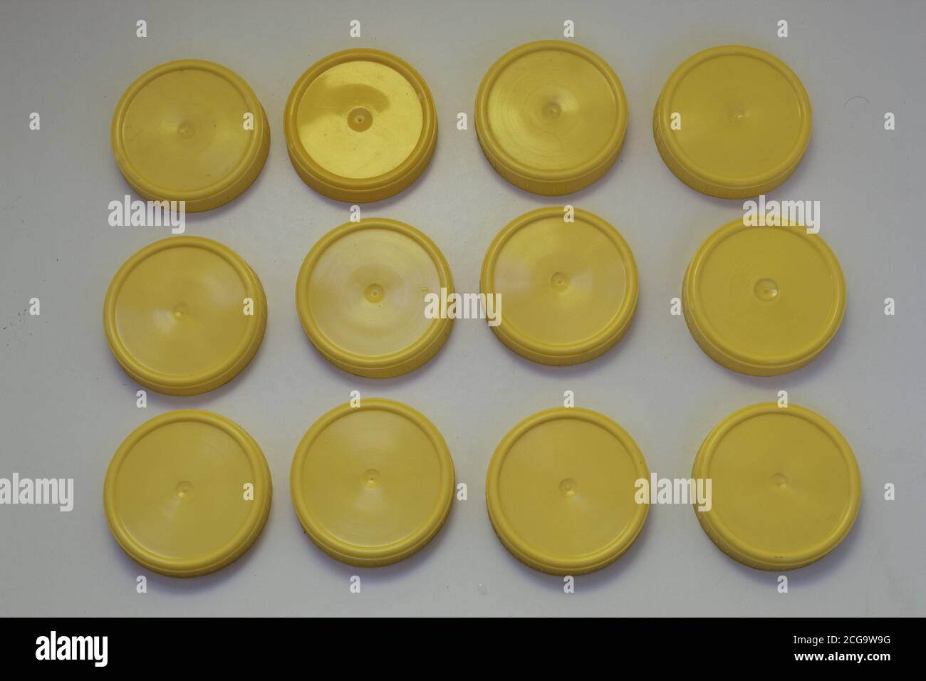 Twelve plastic yellow round lids for jars on a white background Stock ...