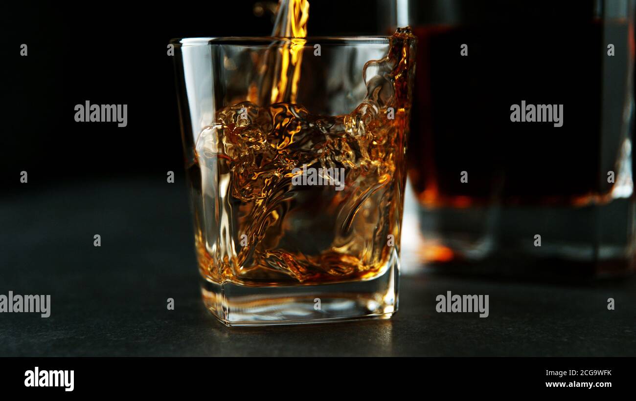 Detail of pouring whiskey into glass on black background Stock Photo ...