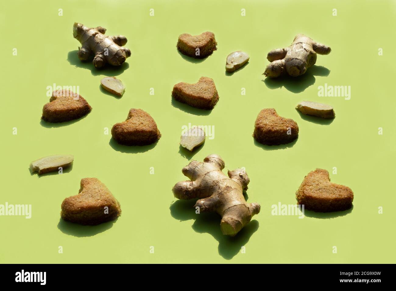 Homemade heart shaped gingerbread cookies and ginger root on a green ...