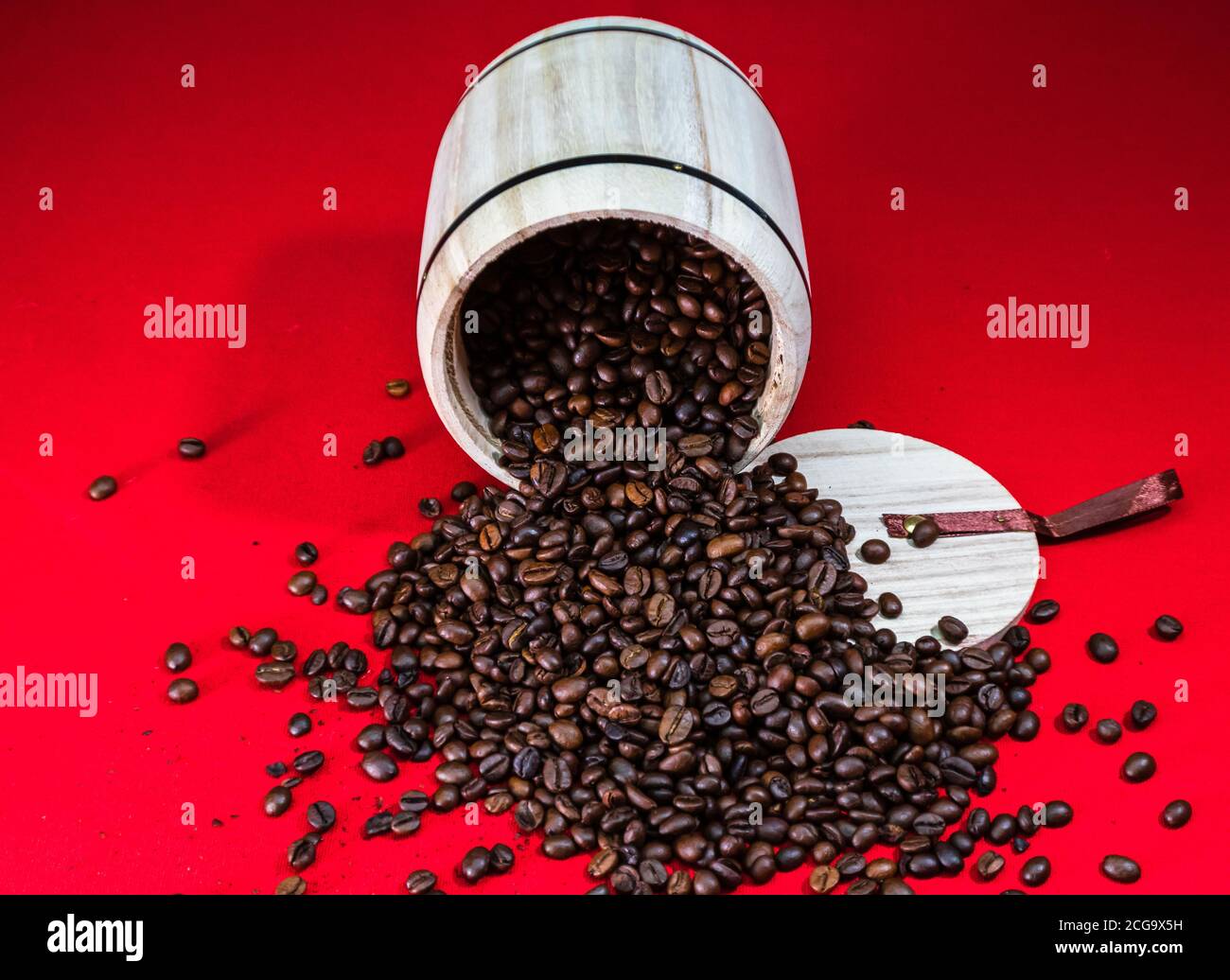 Roasted coffee beans in a wooden coffee jar on red background, coffee concept, coffee detail ...