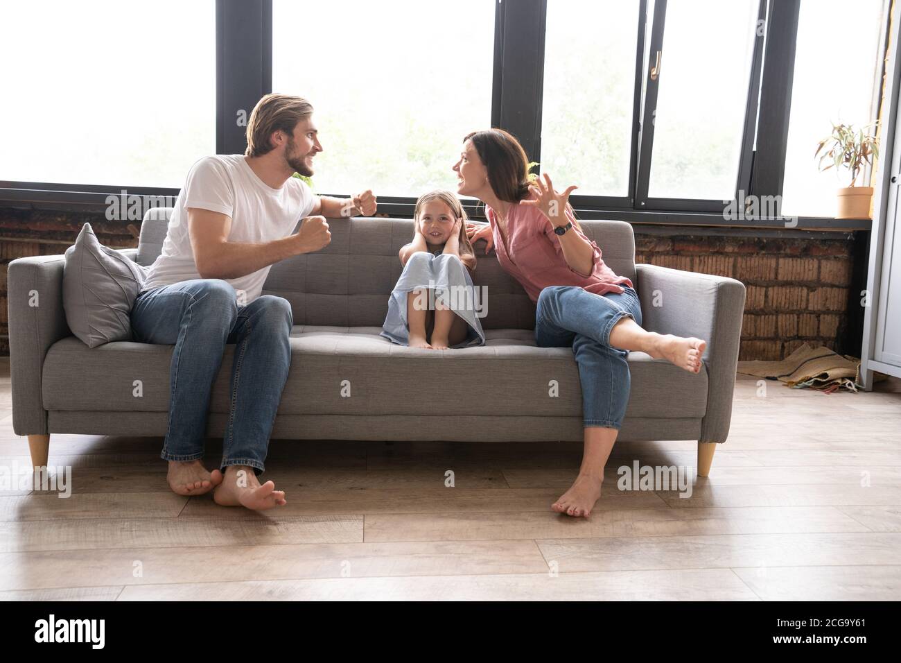 Little girl between arguing parents at home Stock Photo - Alamy