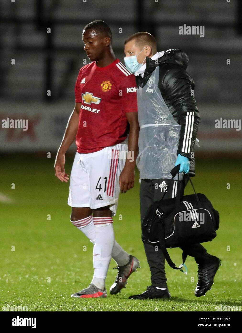 Manchester United's Ethan Laird leaves the field after picking up an ...
