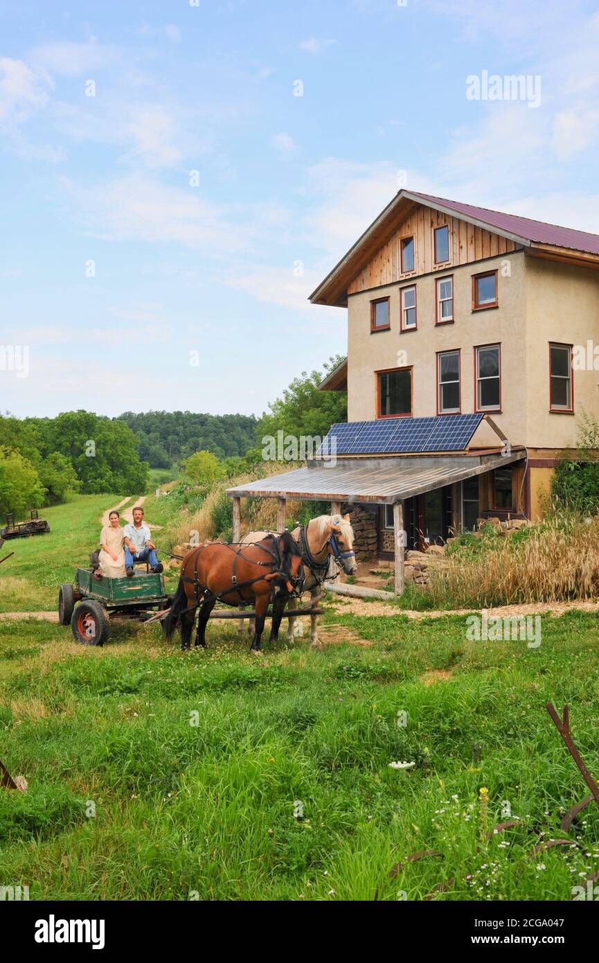 Husband and wife team drive horse drawn wagon in front sustainable ...