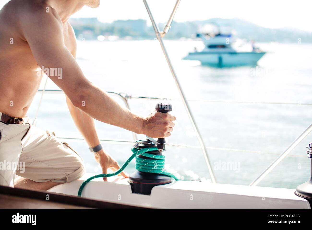Cropped view of yacht captain working on the boat with winch on a ...