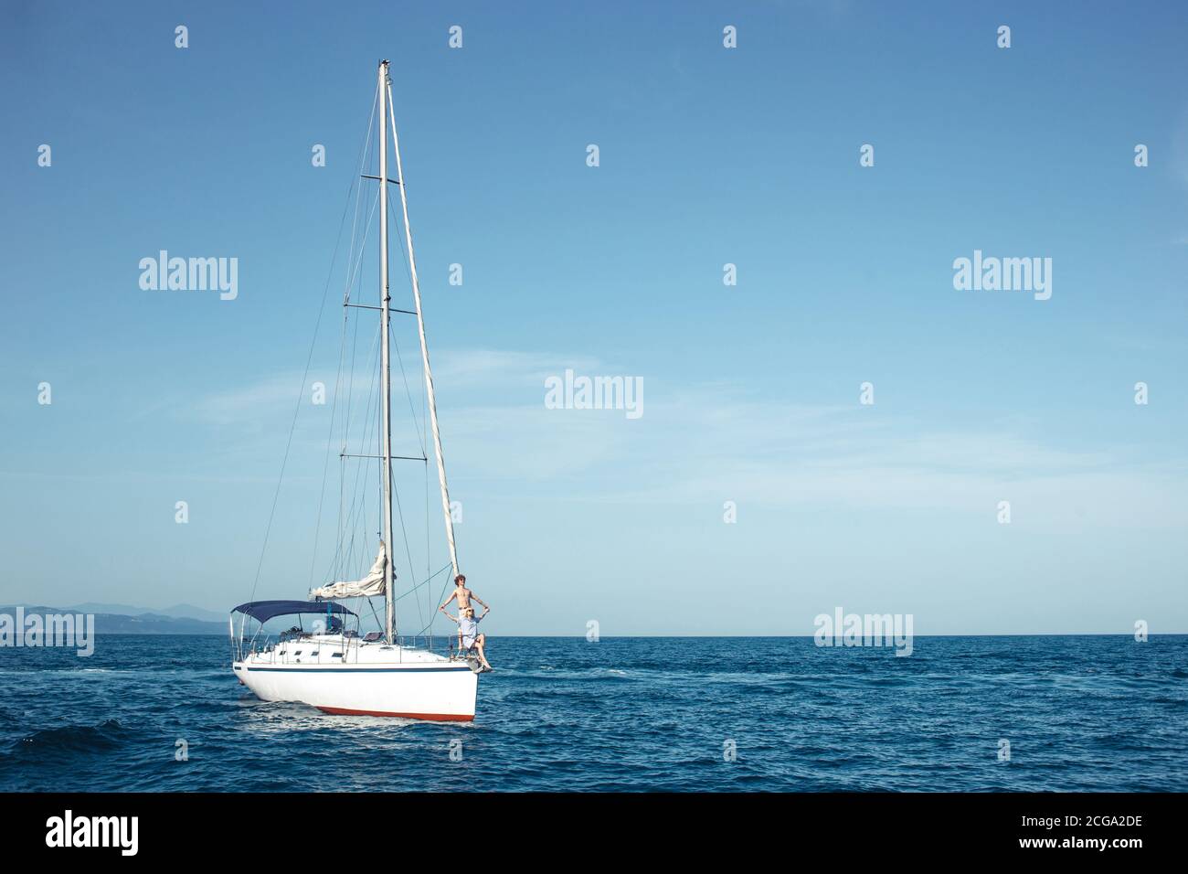 Floating yacht with sails down in calm sea. A boat lowered the sails ...