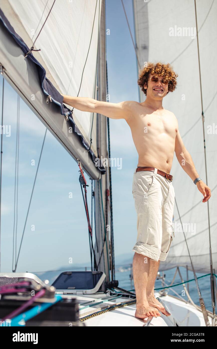 sailing, vacation, tourism, travel and people concept - young handsome ...