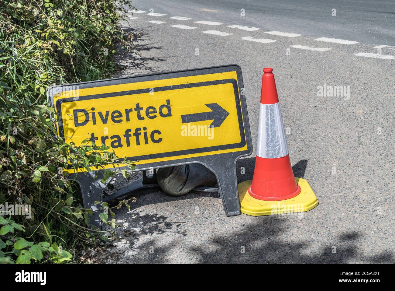 UK road transport system. Orange and white road cone & diverted traffic ...