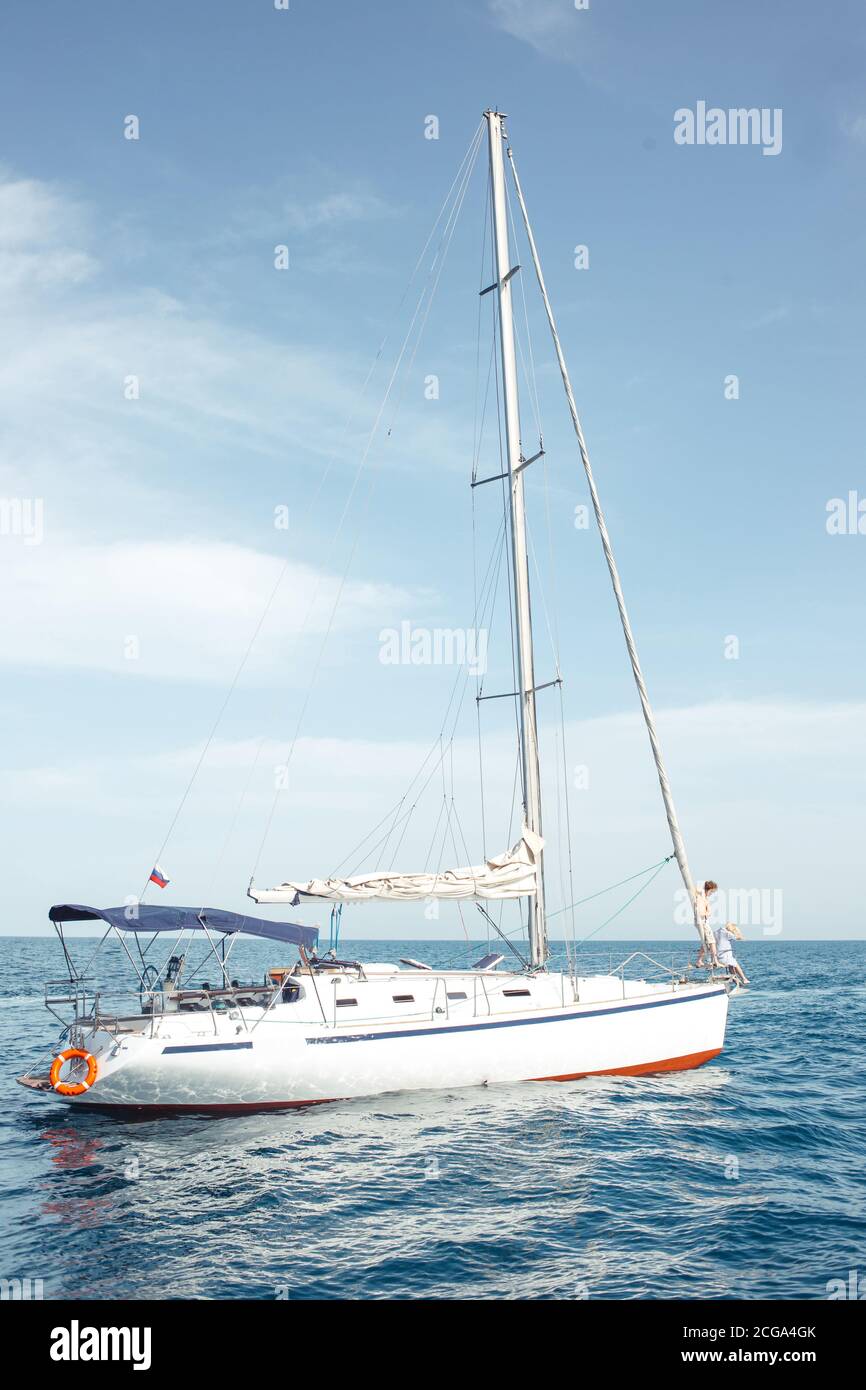 Floating yacht with sails down in calm sea. A boat lowered the sails ...