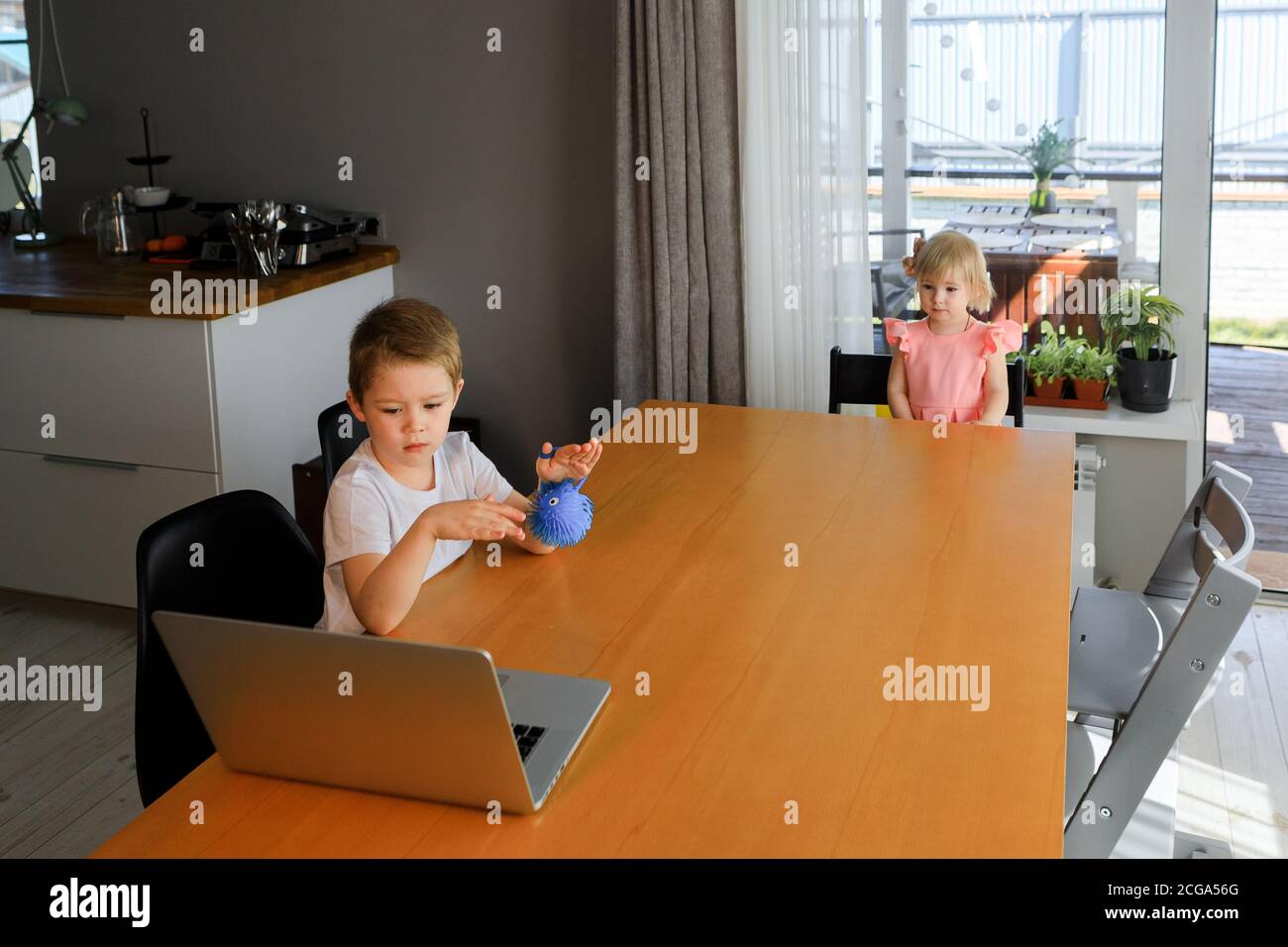 A little boy and a girl watch cartoons on a laptop Stock Photo - Alamy