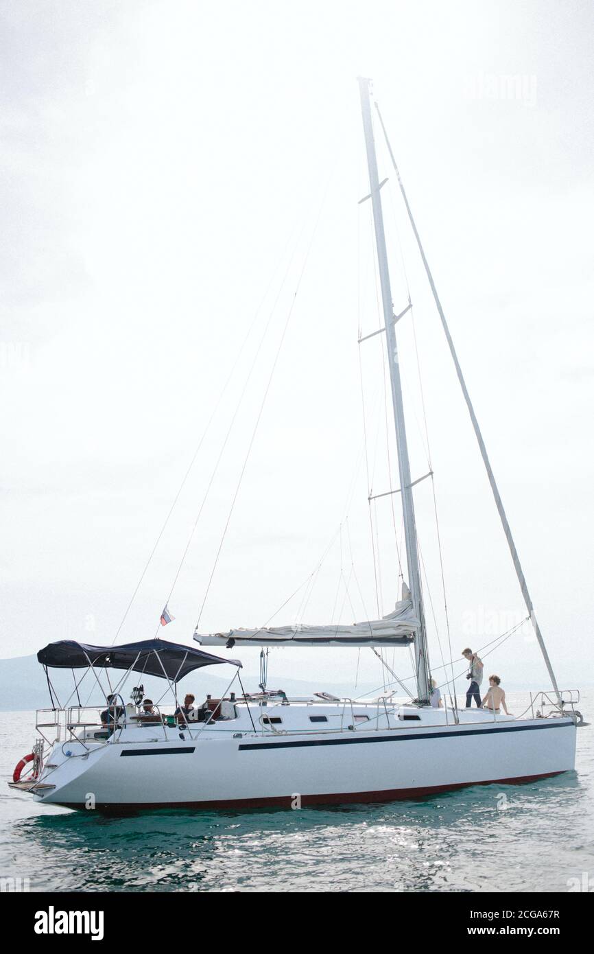 Floating yacht with sails down in calm sea. A boat lowered the sails ...