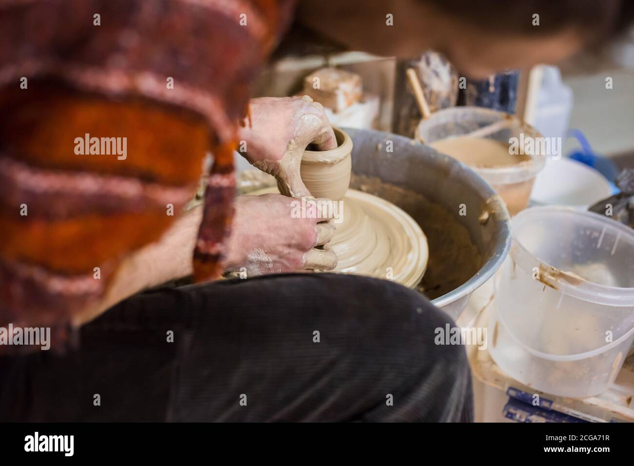 Professional male potter making mug in pottery workshop, studio ...