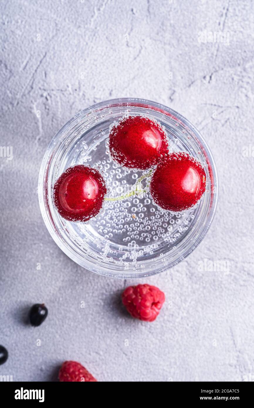 Fresh cold sparkling water drink with cherry, raspberry and currant ...