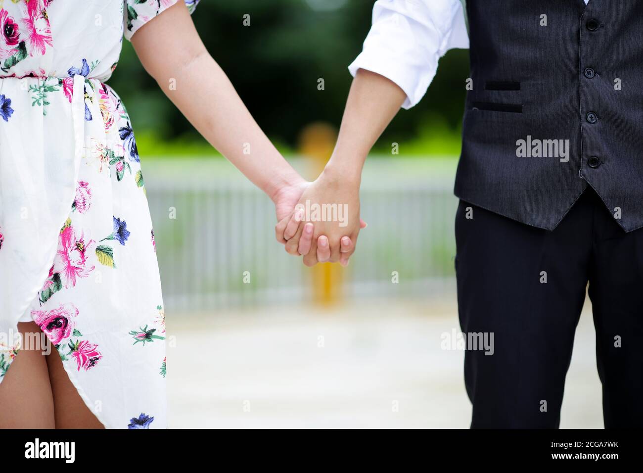 Couple man and woman hold hands on sunset background Stock Photo - Alamy