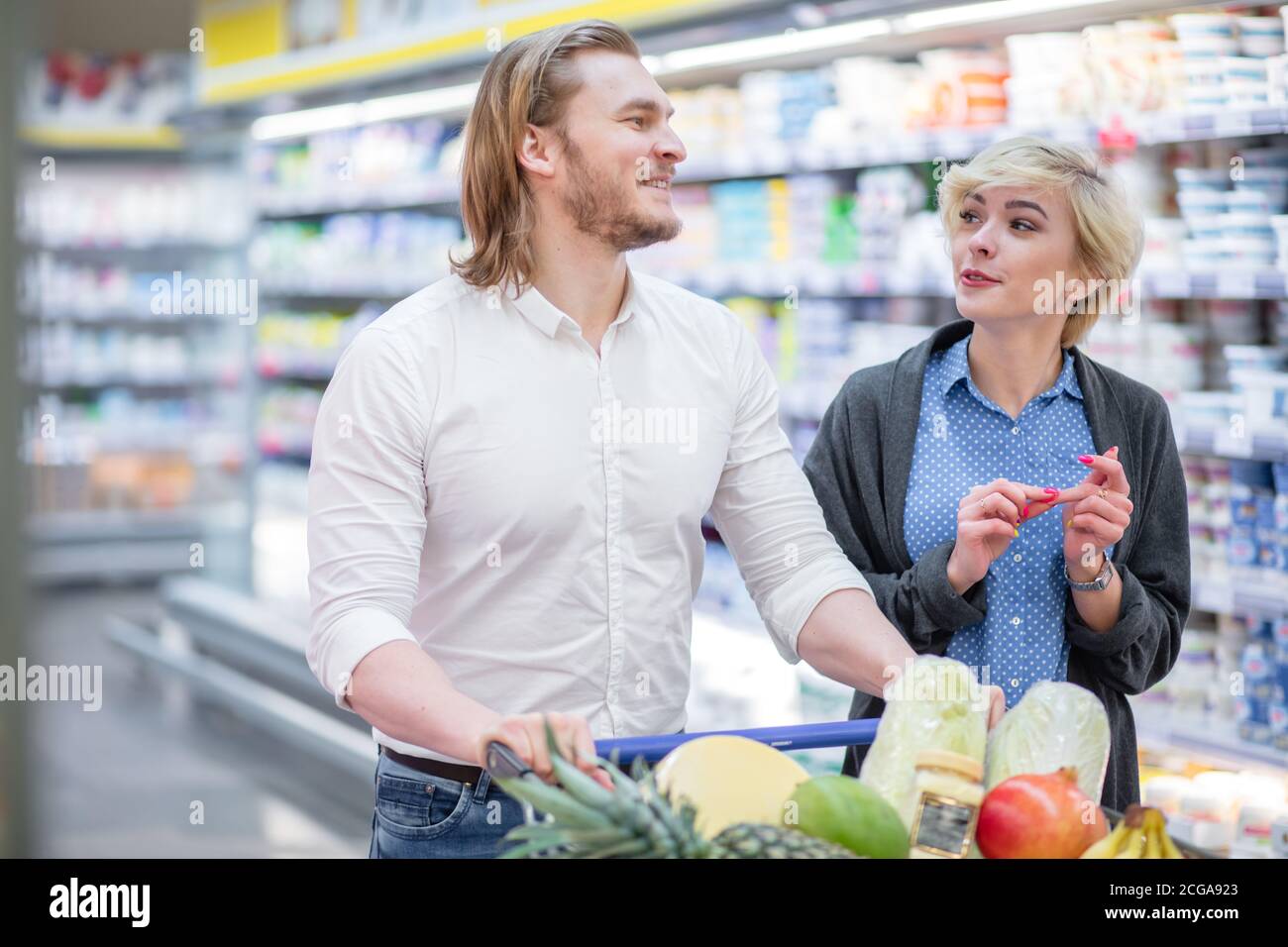 Consumerism concept. Ordinary aucasian family going among shelves with ...