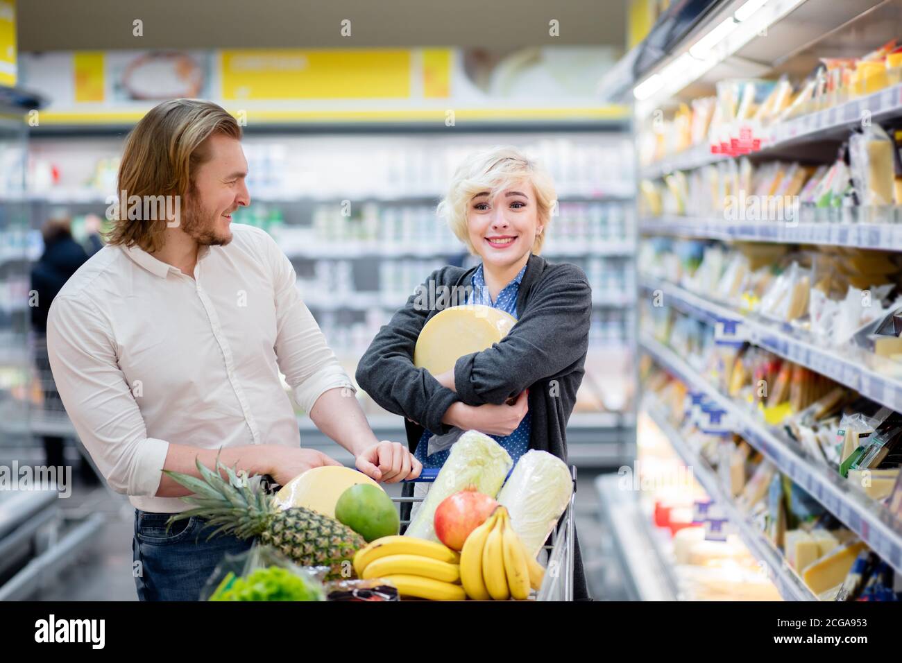 Positive family customers with full trolley of healthy organic ...