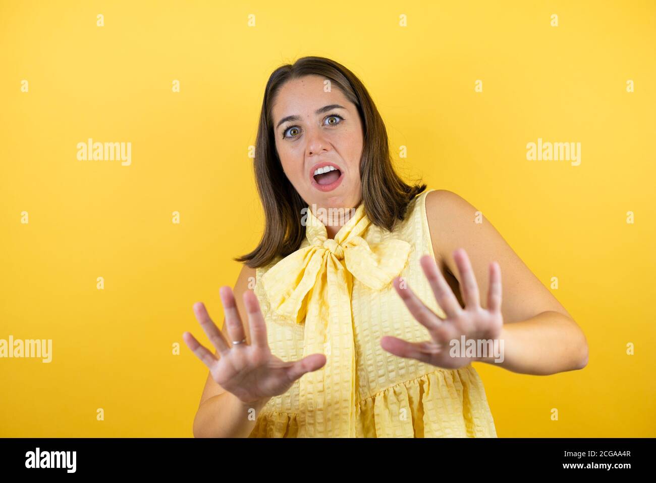 Young beautiful woman over isolated yellow background afraid and ...