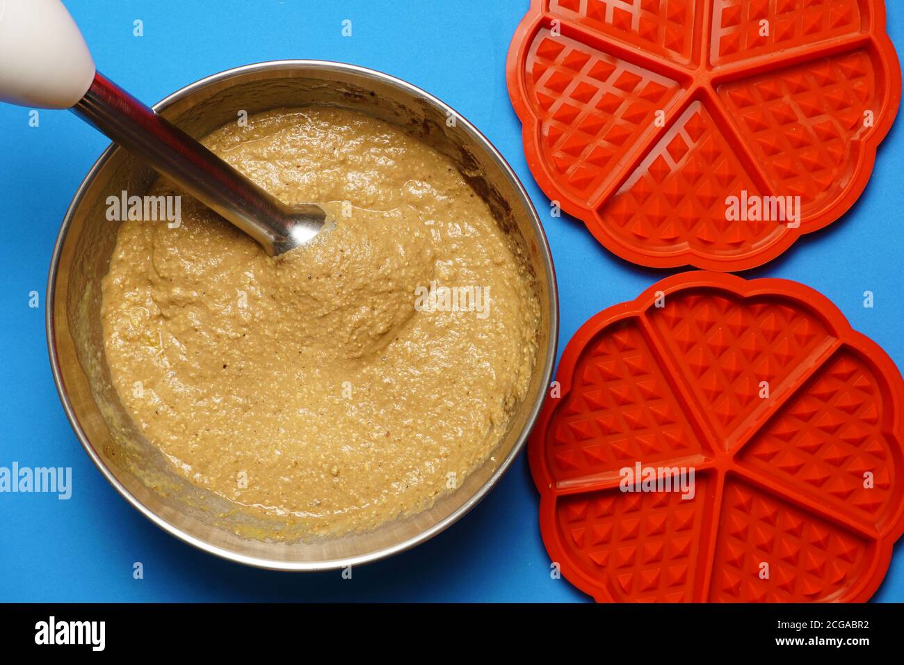 top view of cake mix in bowl with mixer and molds beside. cooking ...
