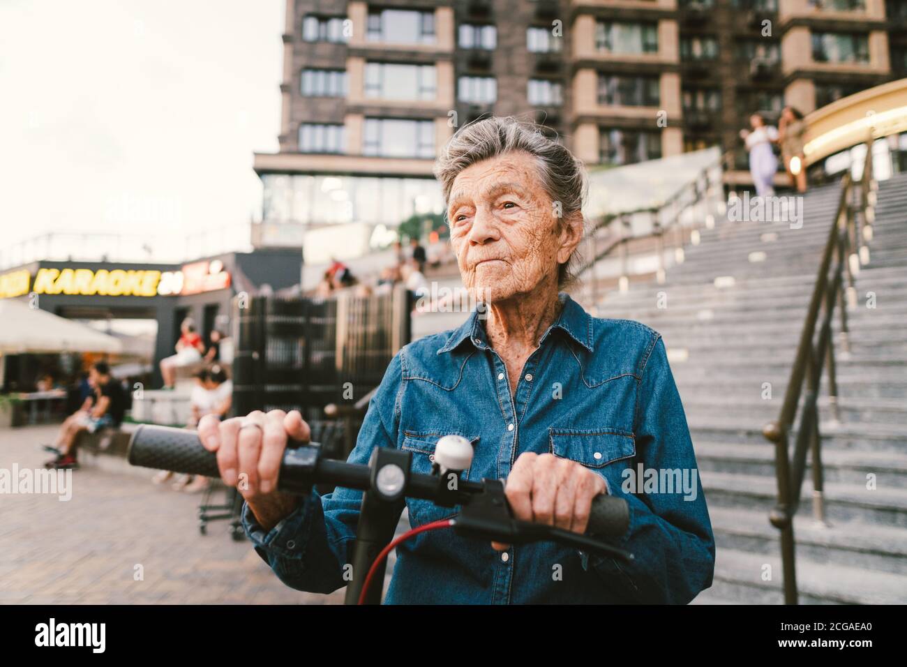 Old woman near scooter. Grandmother progressive woman. Senior having ...