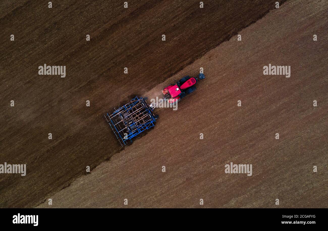 Farmer with tractor tilling the field to open the soil Stock Photo - Alamy